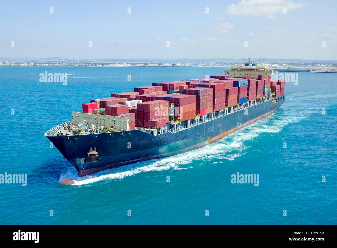 Aerial image of a large container ship at sea, loaded with various ...