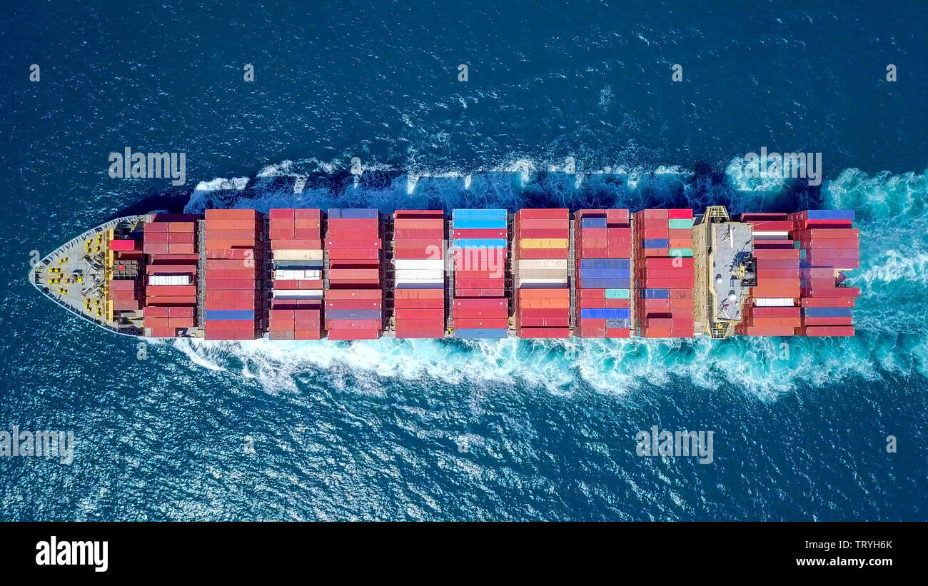 Aerial image of a large container ship at sea, loaded with various ...