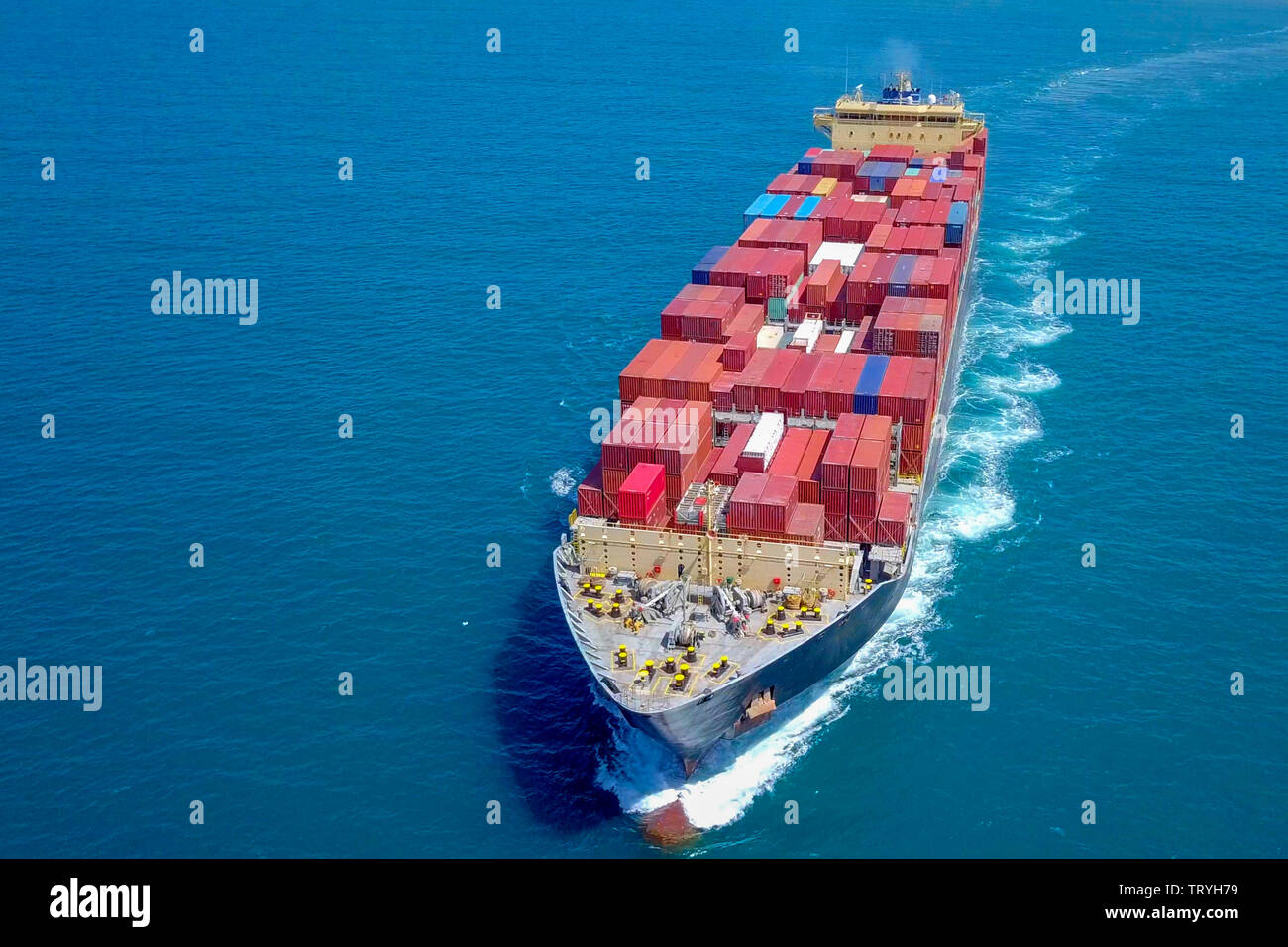 Aerial image of a large container ship at sea, loaded with various ...