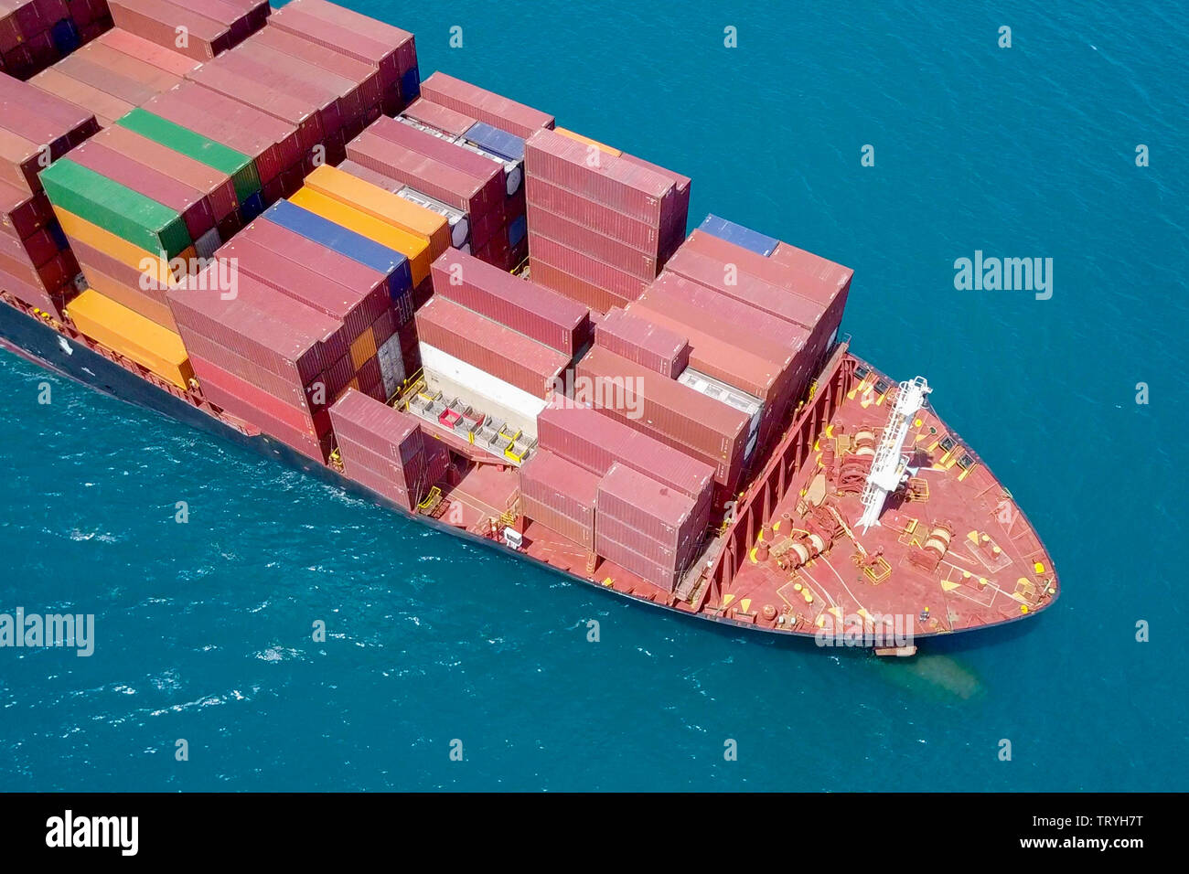 Aerial image of a large container ship at sea, loaded with various ...