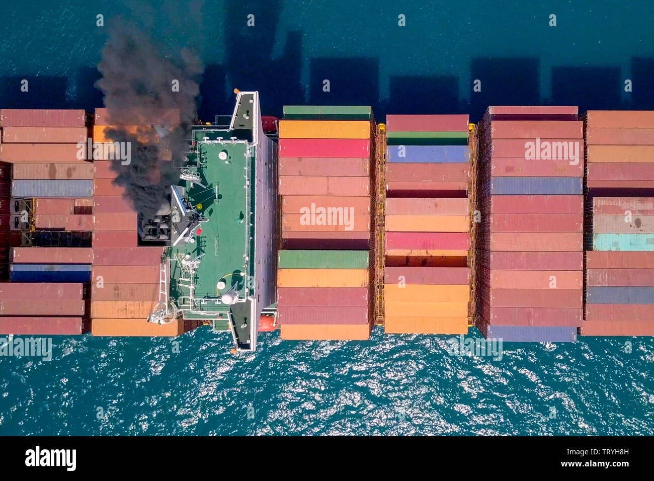 Aerial image of a large container ship at sea, loaded with various ...