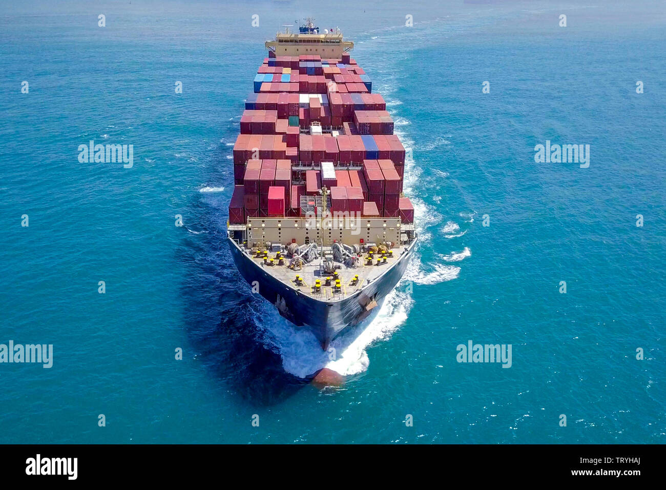 Aerial image of a large container ship at sea, loaded with various ...