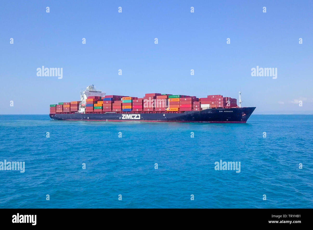 Aerial image of a large container ship at sea, loaded with various ...