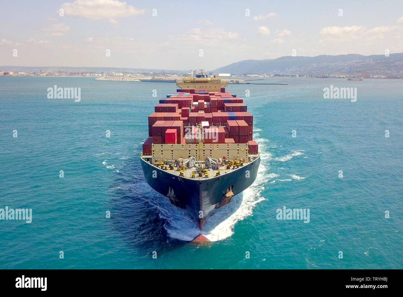 Aerial image of a large container ship at sea, loaded with various ...