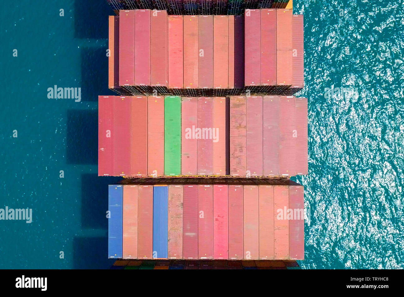 Aerial image of a large container ship at sea, loaded with various ...