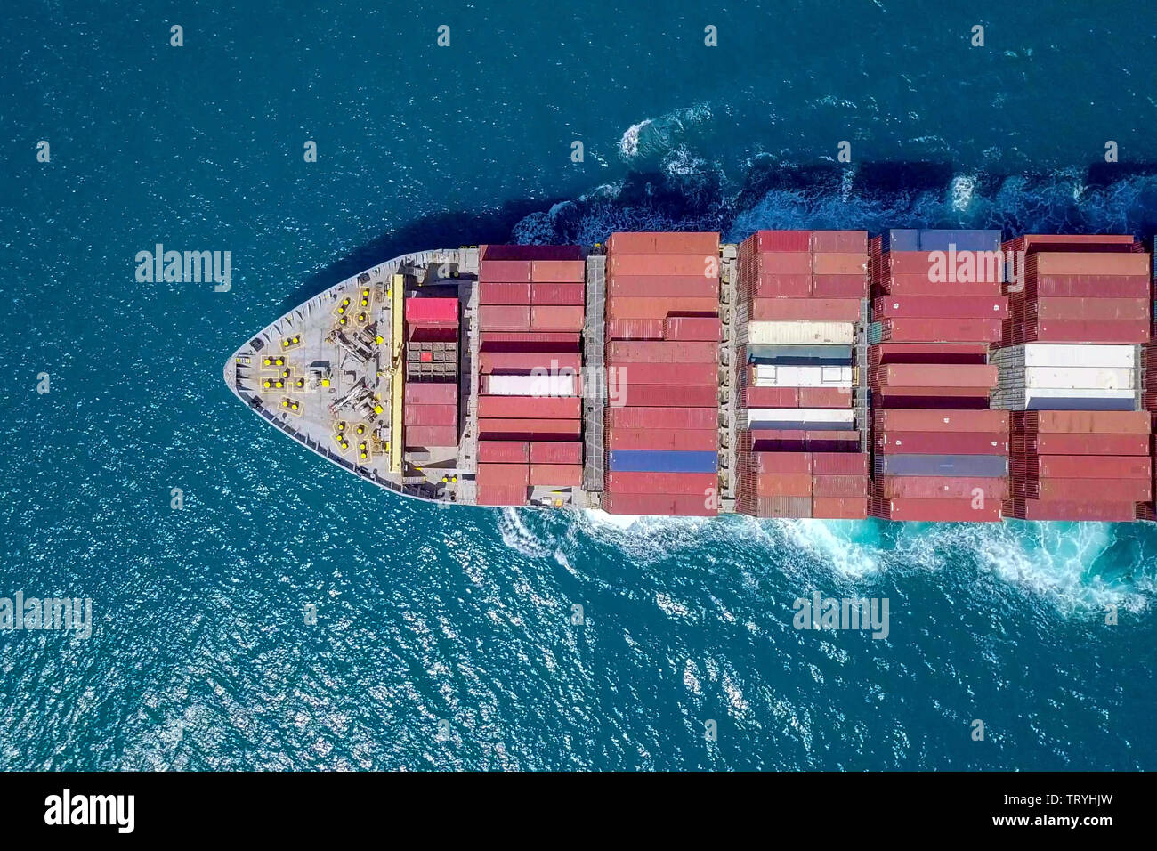 Aerial image of a large container ship at sea, loaded with various ...