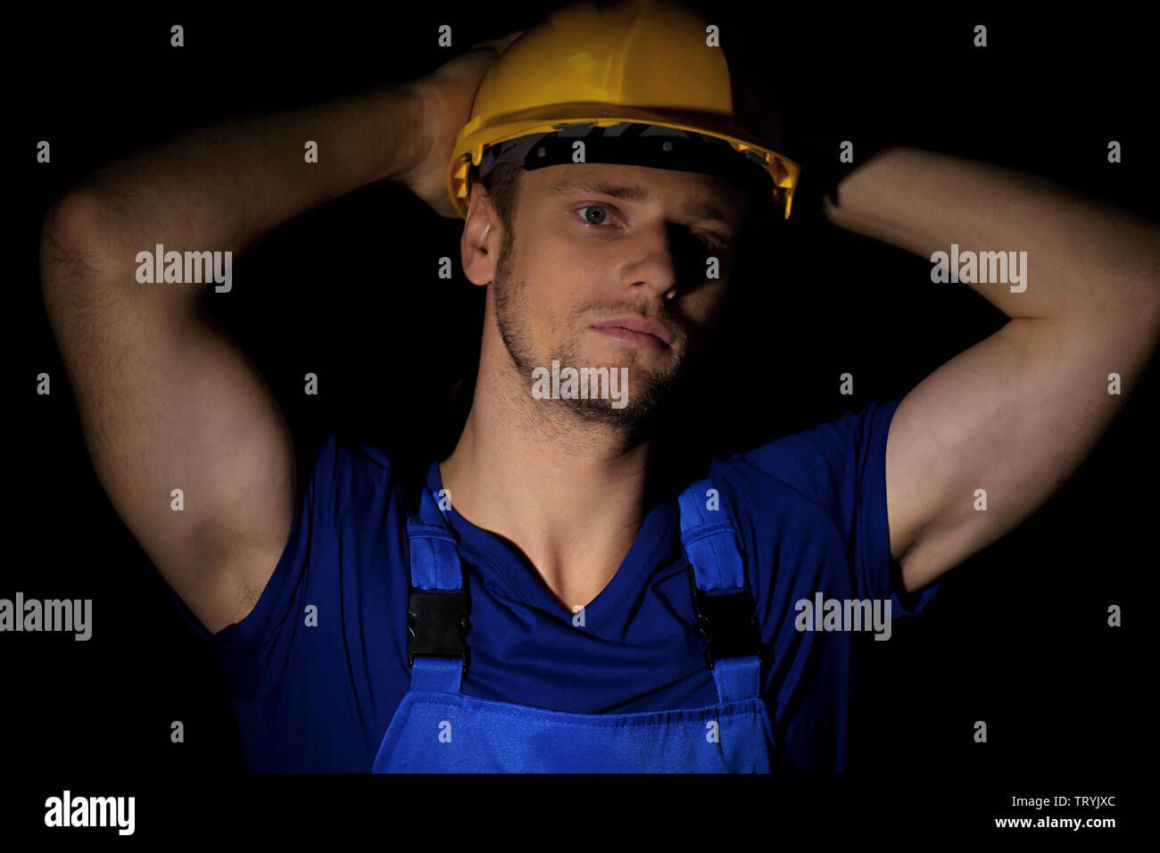 Portrait of young worker on dark background Stock Photo - Alamy