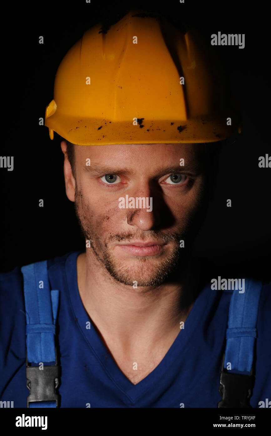 Portrait of young worker on dark background Stock Photo - Alamy