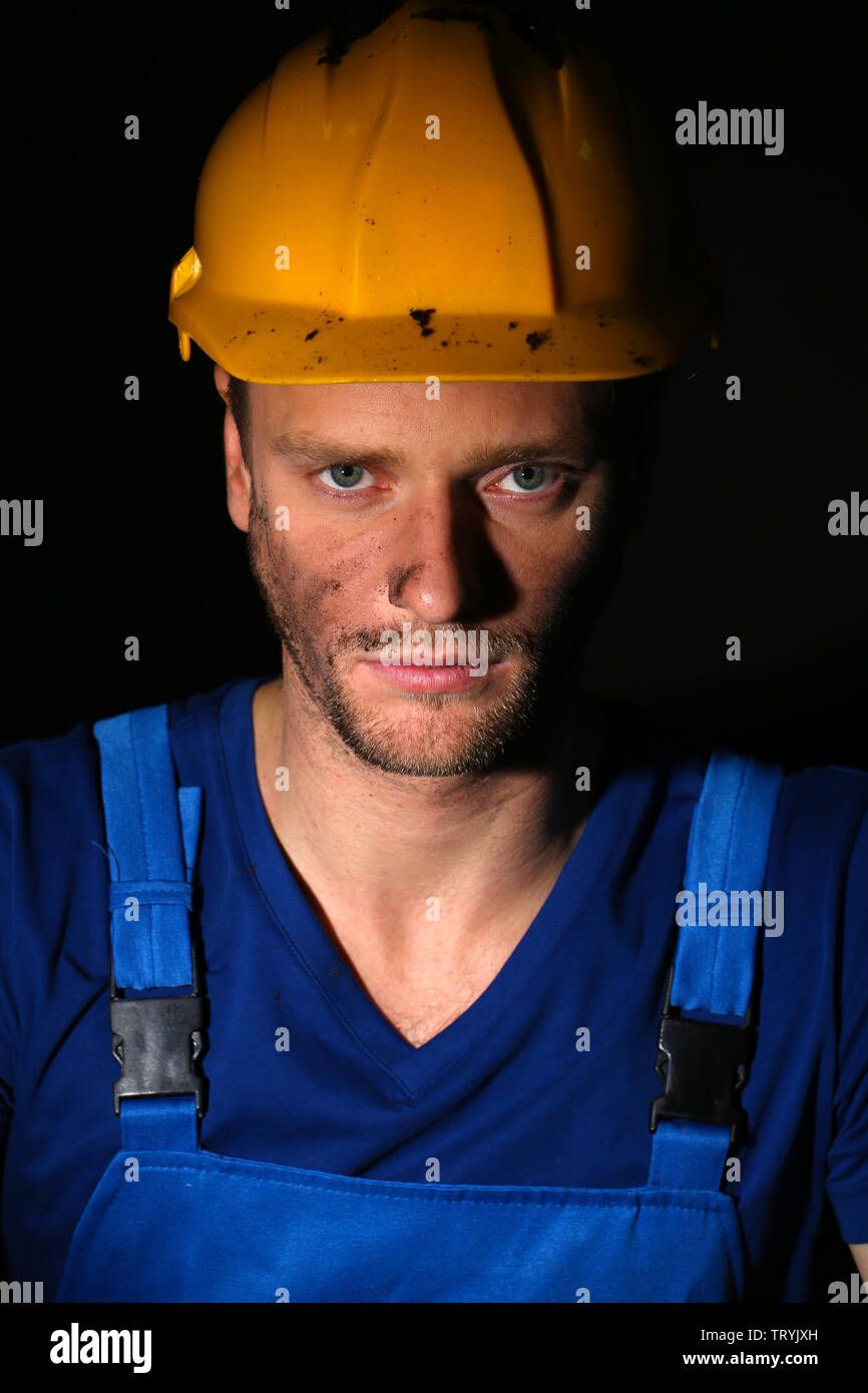 Portrait of young worker on dark background Stock Photo - Alamy
