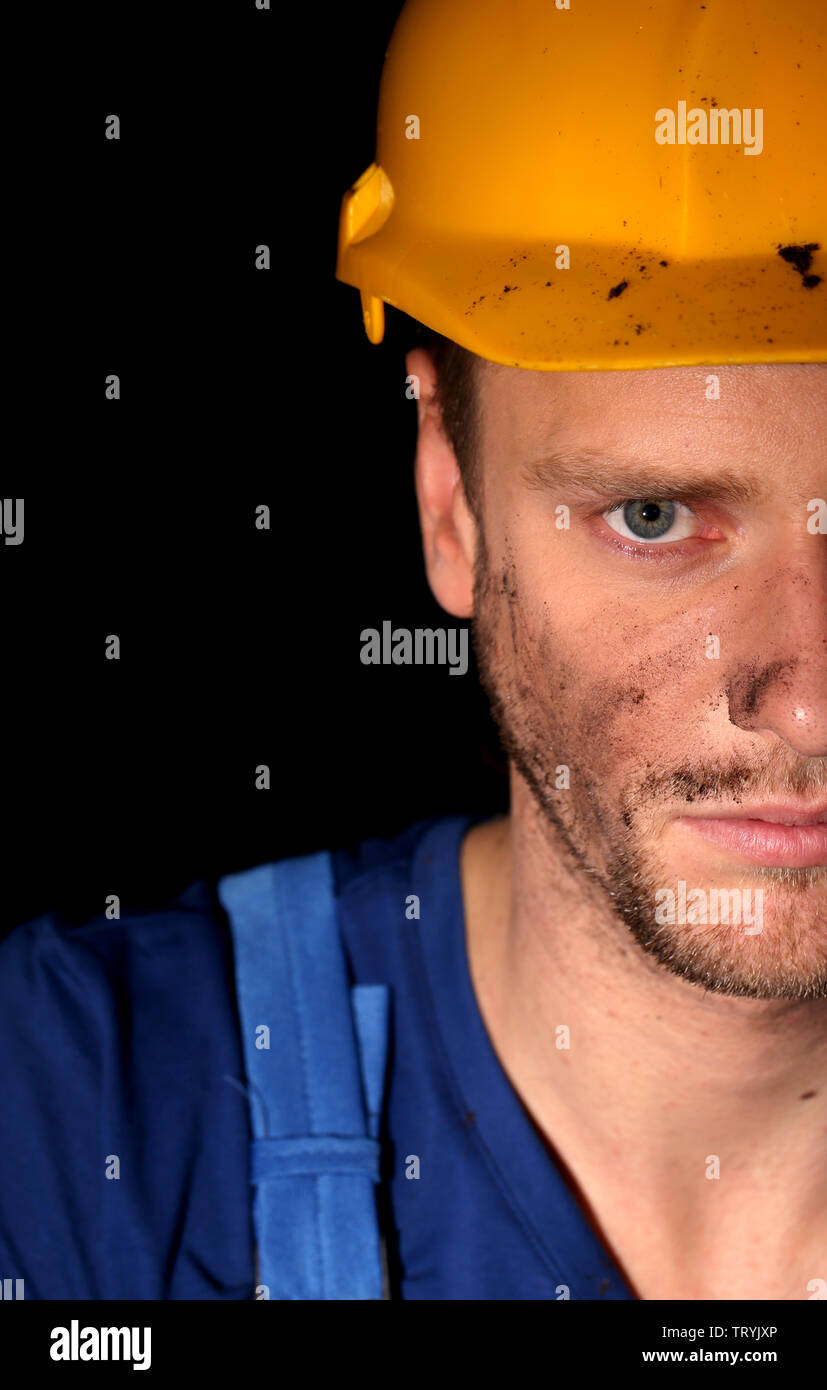 Portrait of young worker on dark background Stock Photo - Alamy