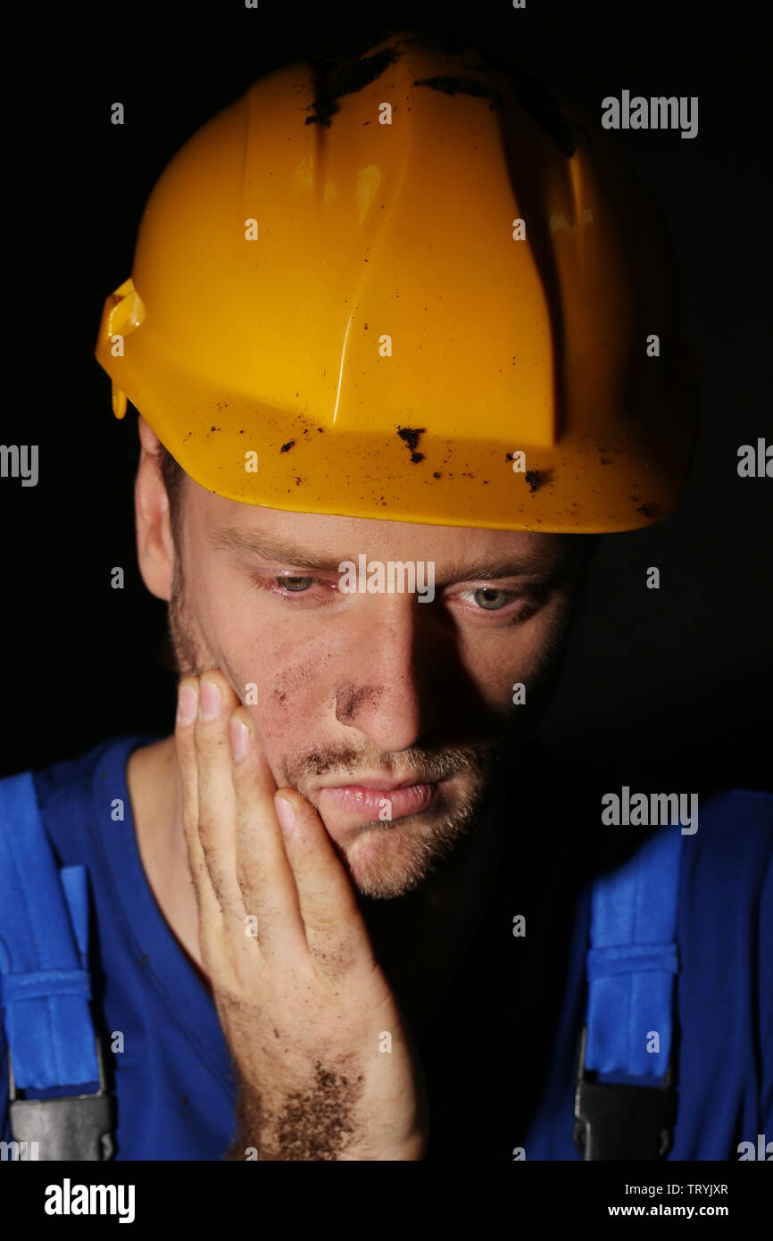 Portrait of young worker on dark background Stock Photo - Alamy