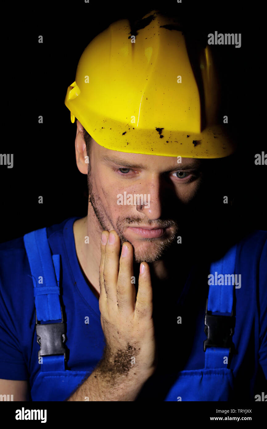 Portrait of young worker on dark background Stock Photo - Alamy