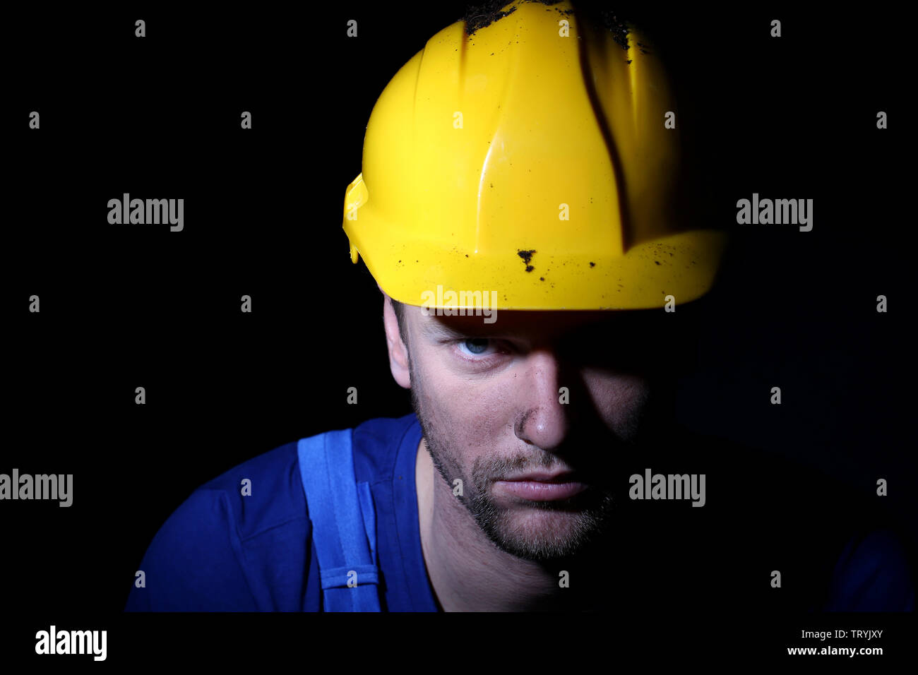 Portrait of young worker on dark background Stock Photo - Alamy