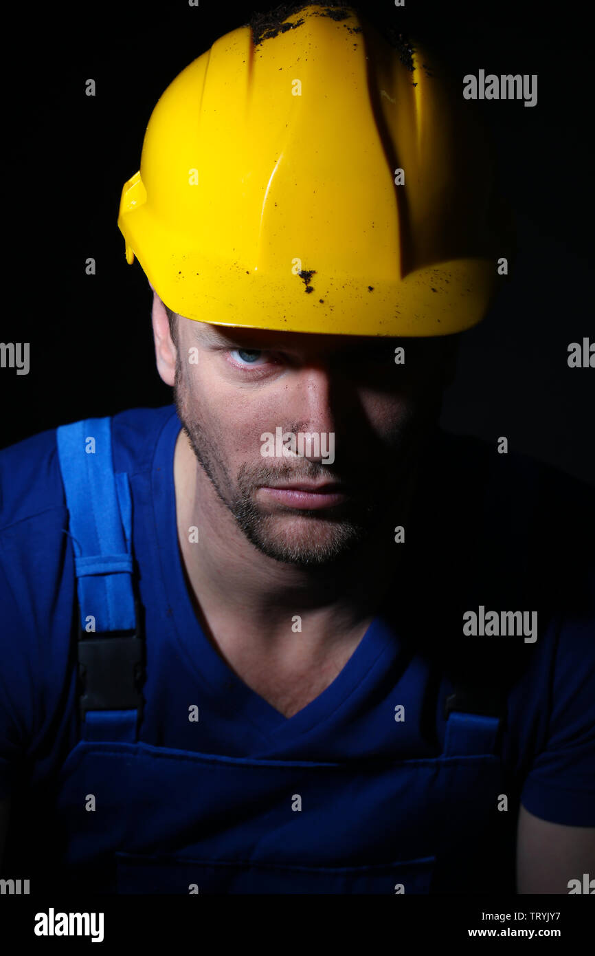 Portrait of young worker on dark background Stock Photo - Alamy