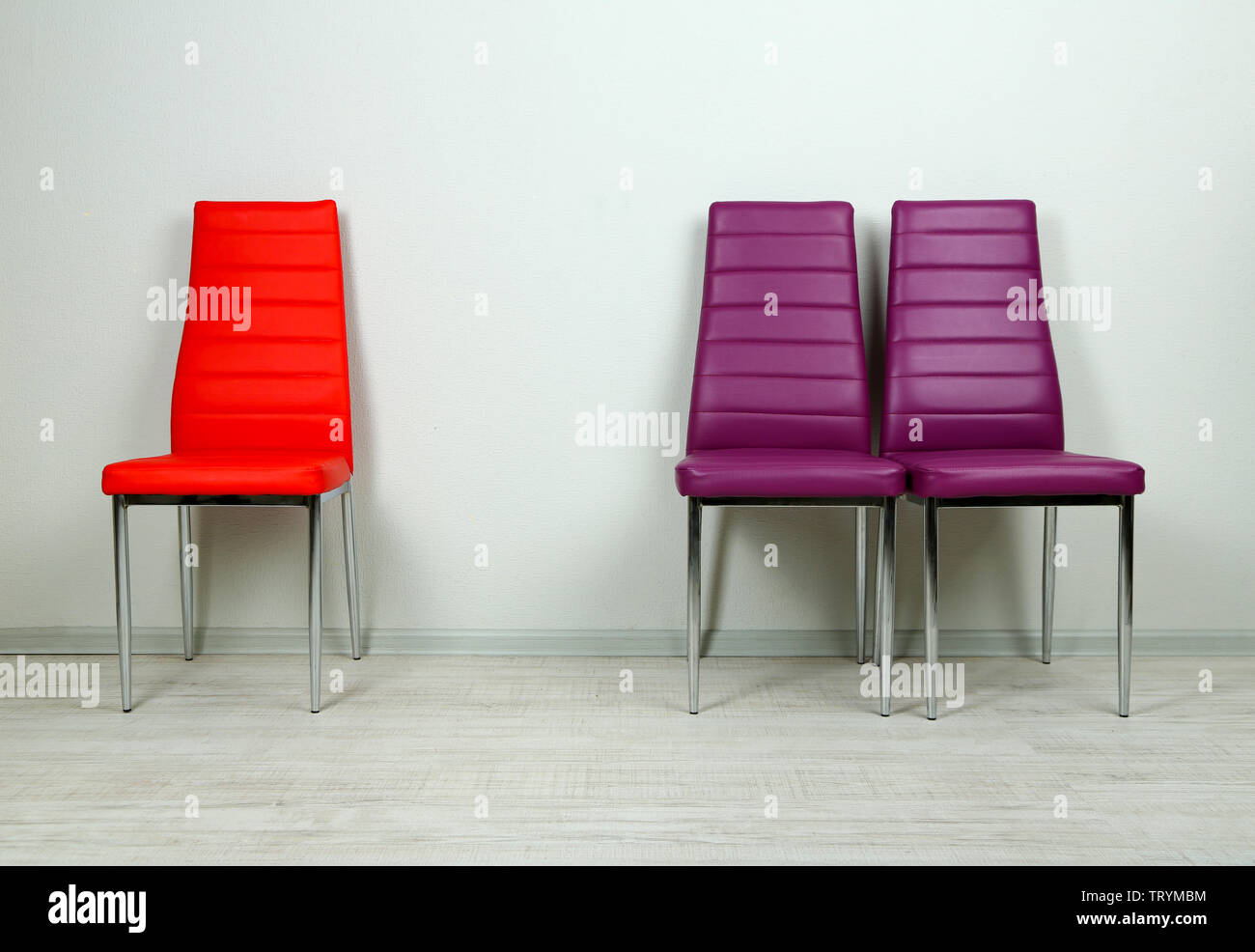 Modern color chairs on wall background Stock Photo - Alamy