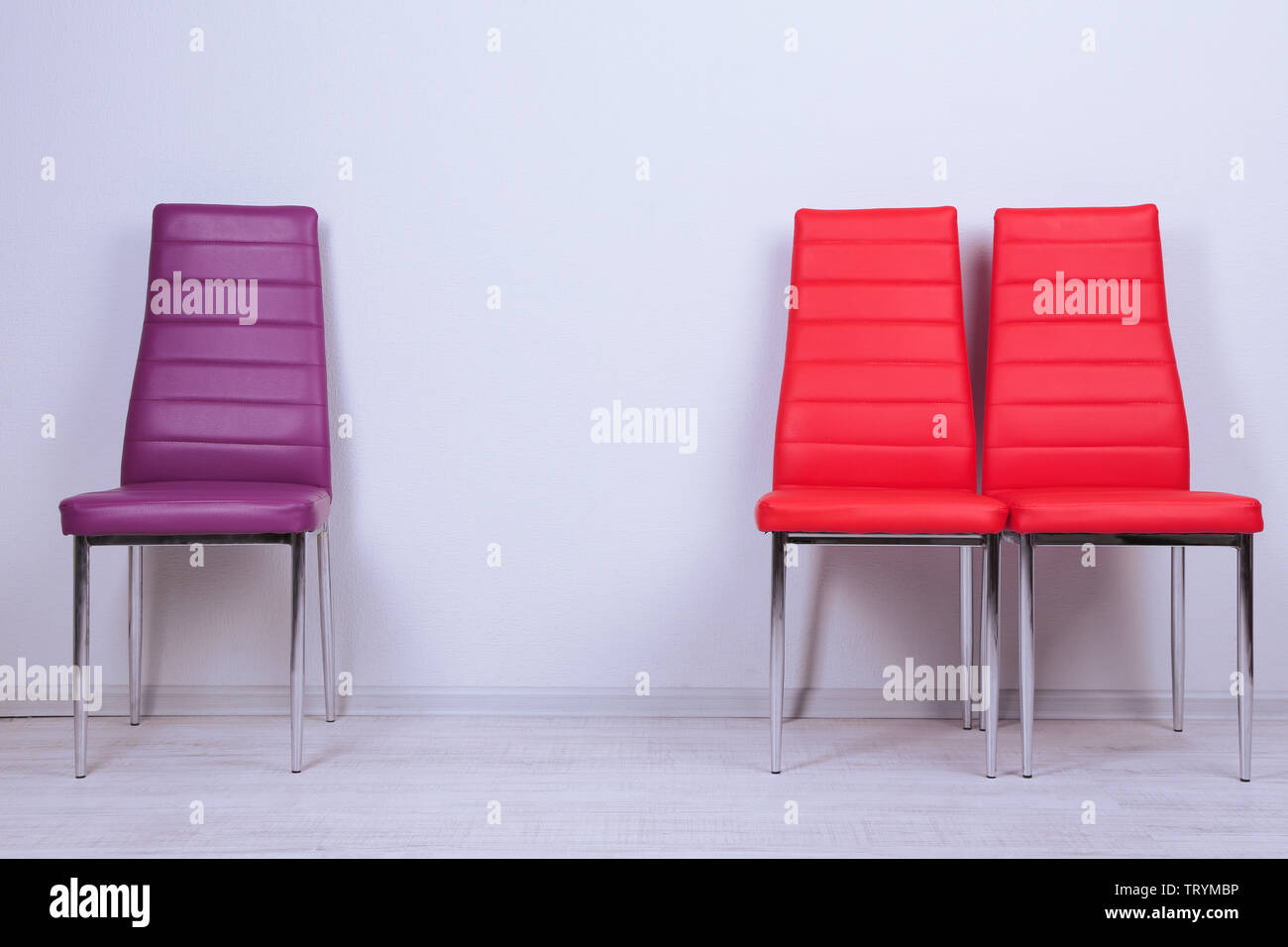 Modern color chairs on wall background Stock Photo - Alamy
