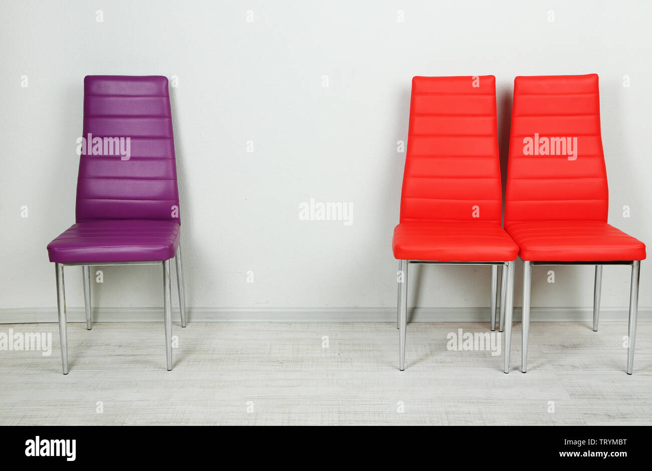 Modern color chairs on wall background Stock Photo - Alamy