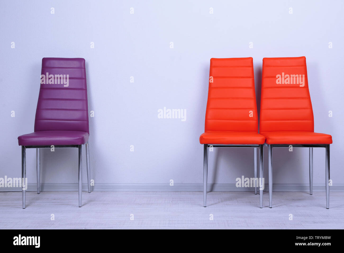 Modern color chairs on wall background Stock Photo - Alamy