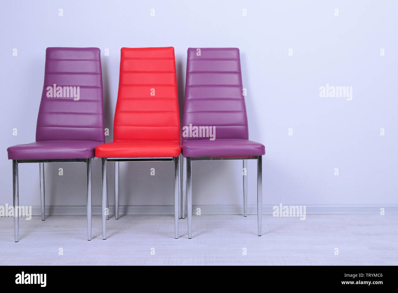Modern color chairs on wall background Stock Photo - Alamy