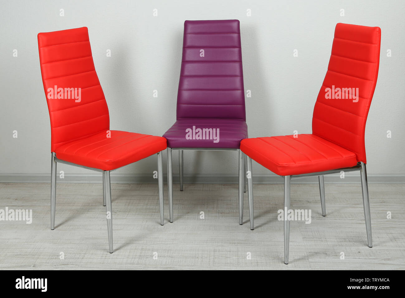 Modern color chairs on wall background Stock Photo - Alamy