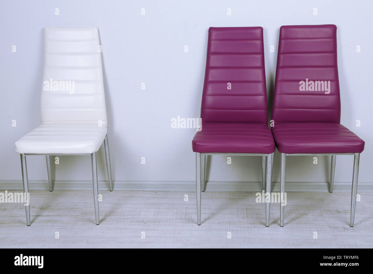 Modern color chairs on wall background Stock Photo - Alamy