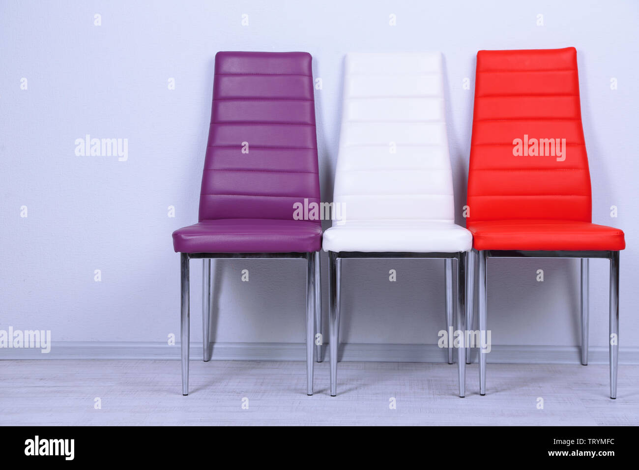 Modern color chairs on wall background Stock Photo - Alamy