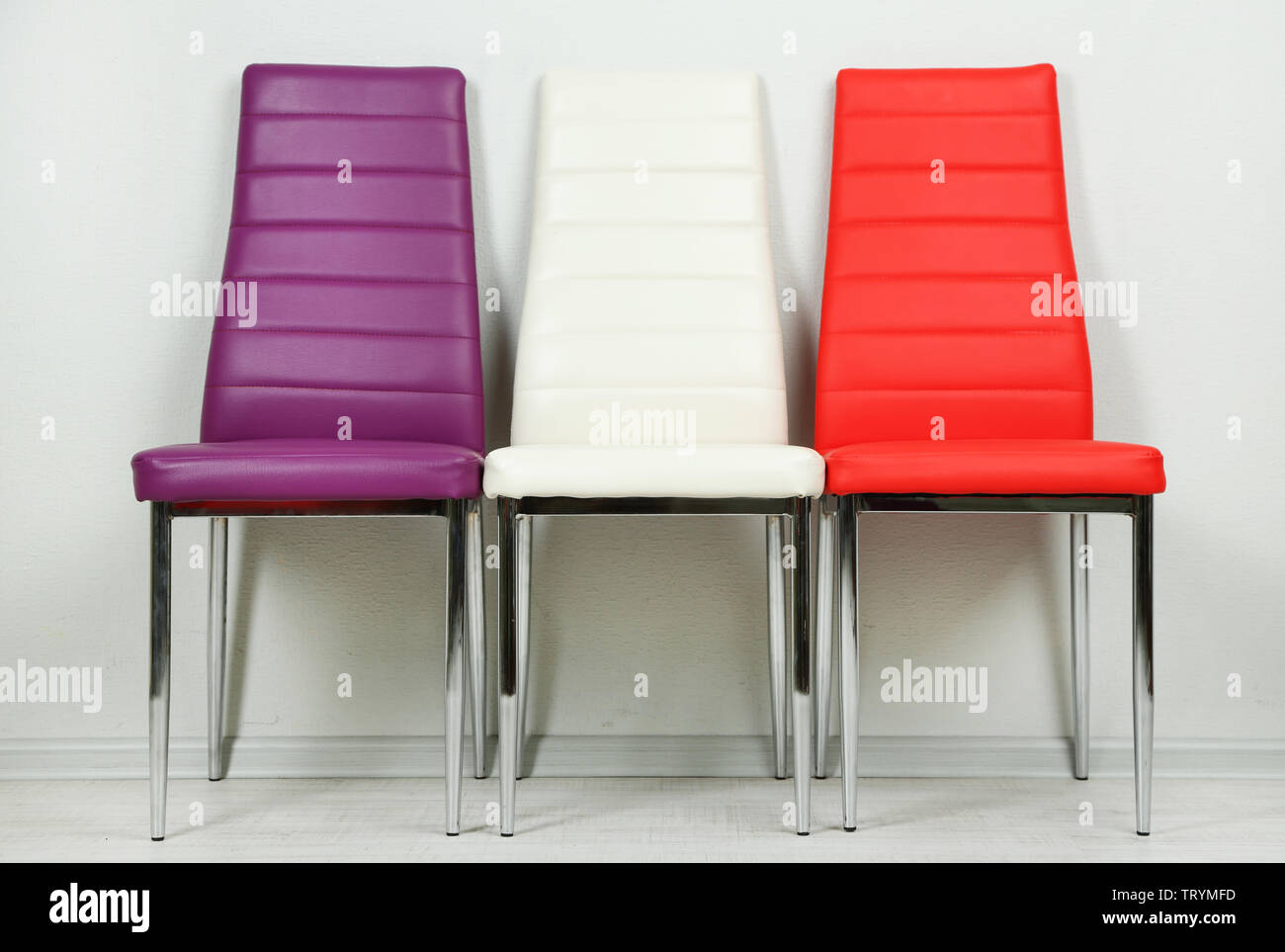 Modern color chairs on wall background Stock Photo - Alamy
