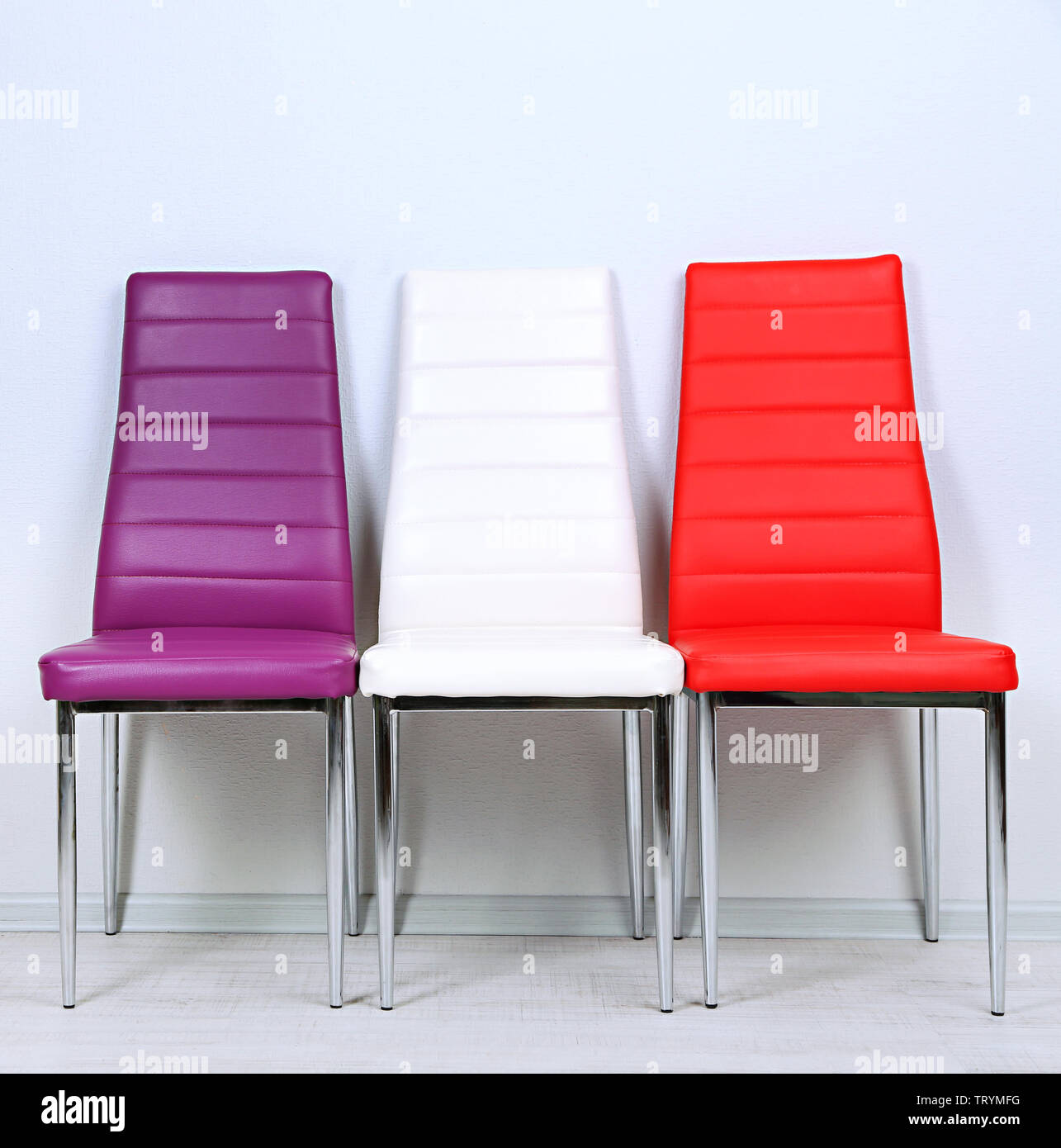 Modern color chairs on wall background Stock Photo - Alamy