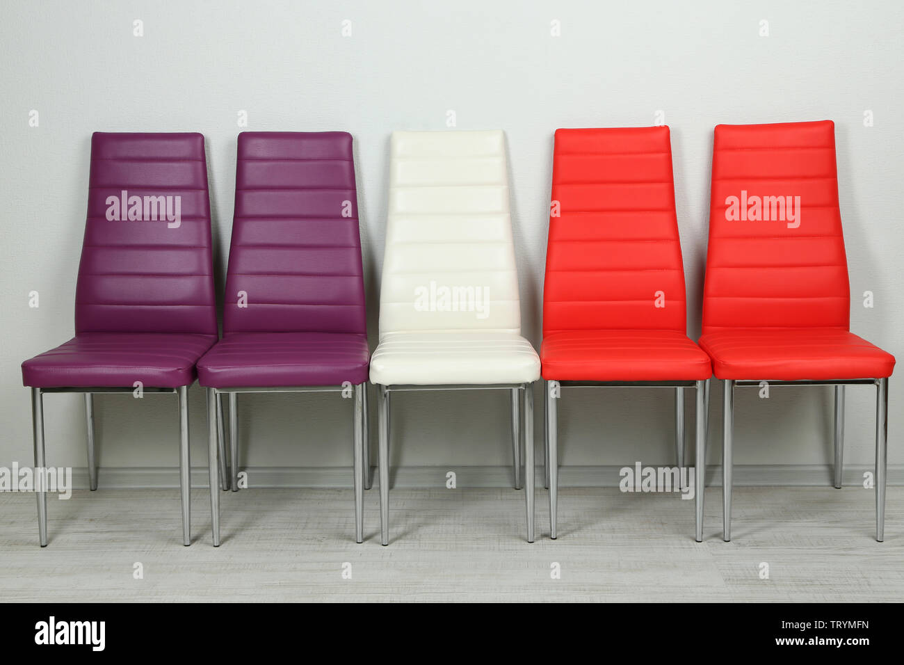 Modern color chairs on wall background Stock Photo - Alamy