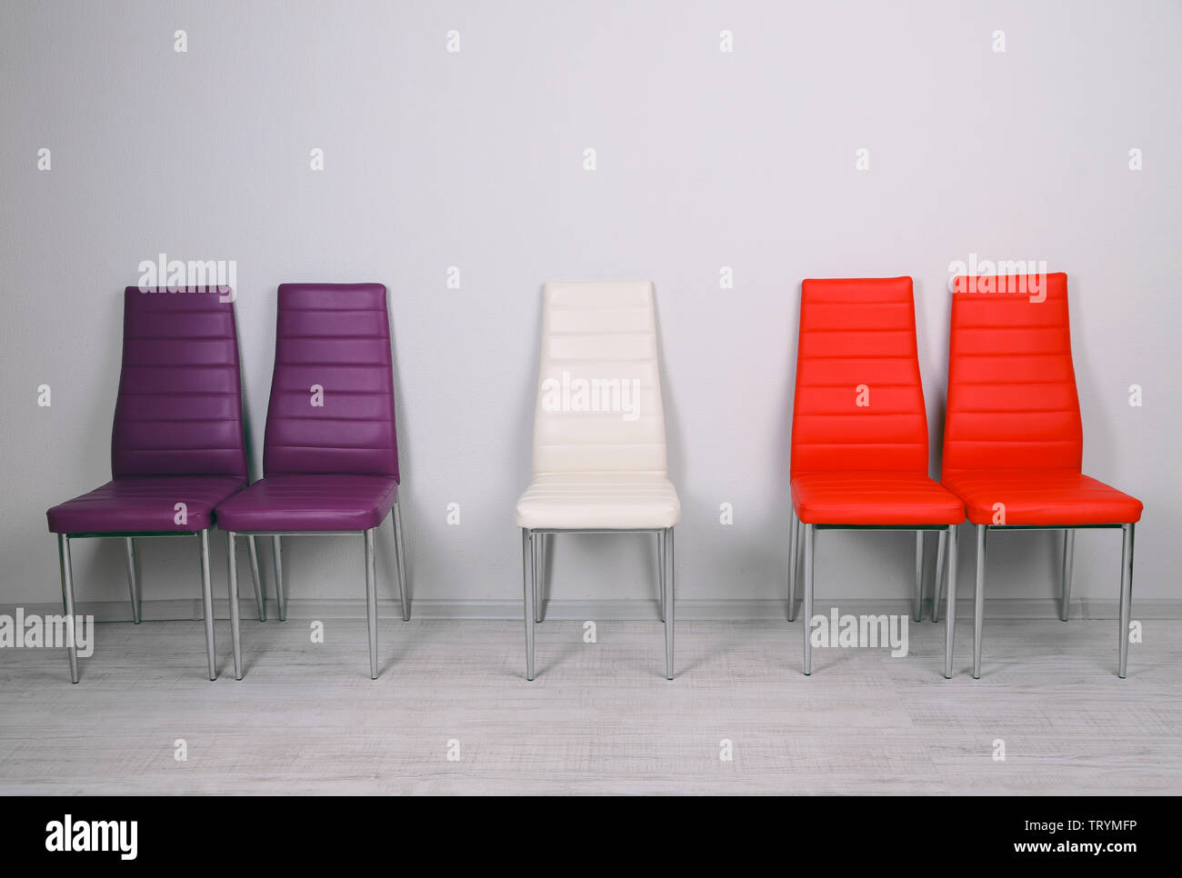 Modern color chairs on wall background Stock Photo - Alamy