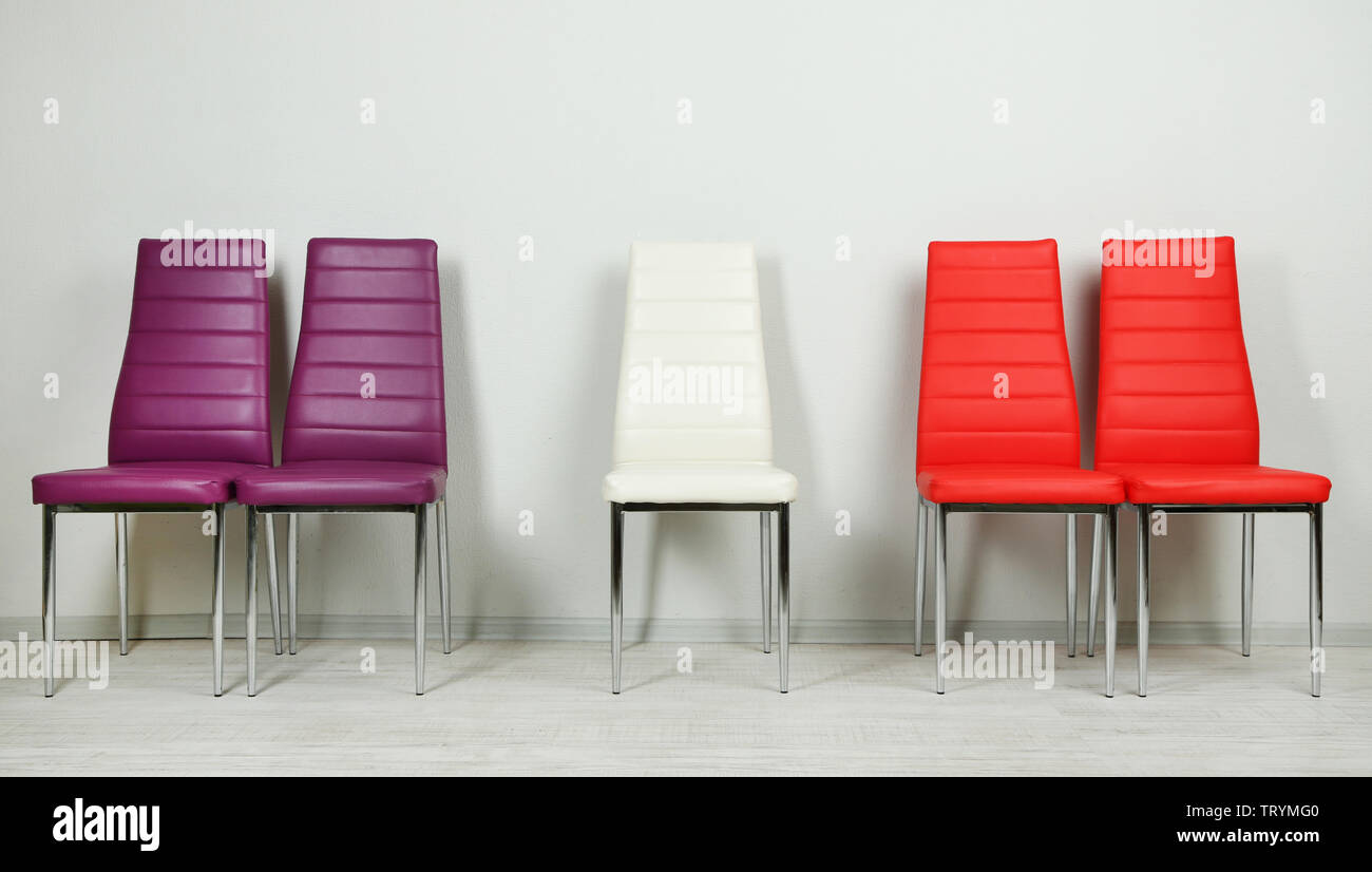 Modern color chairs on wall background Stock Photo - Alamy