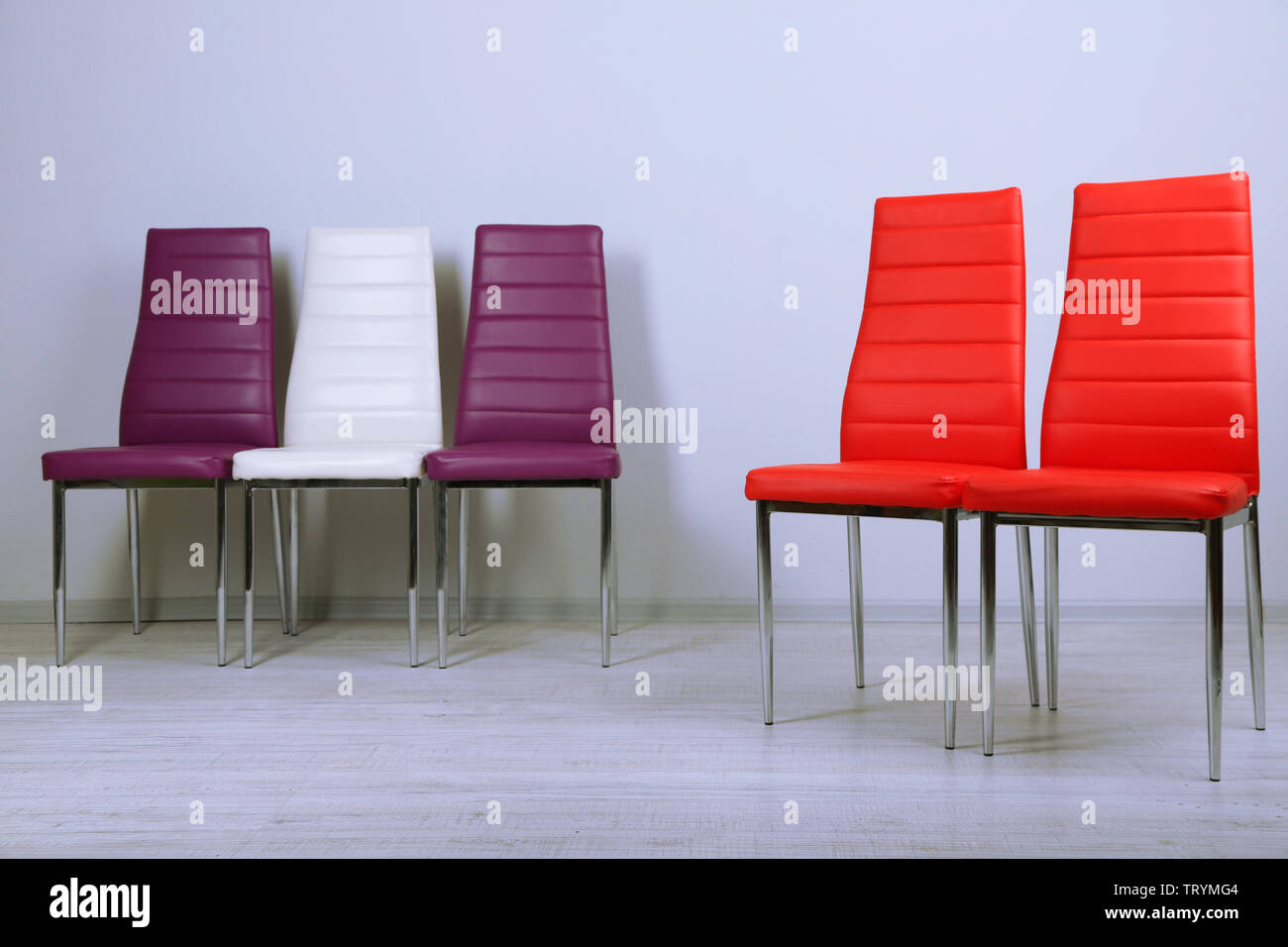 Modern color chairs on wall background Stock Photo - Alamy