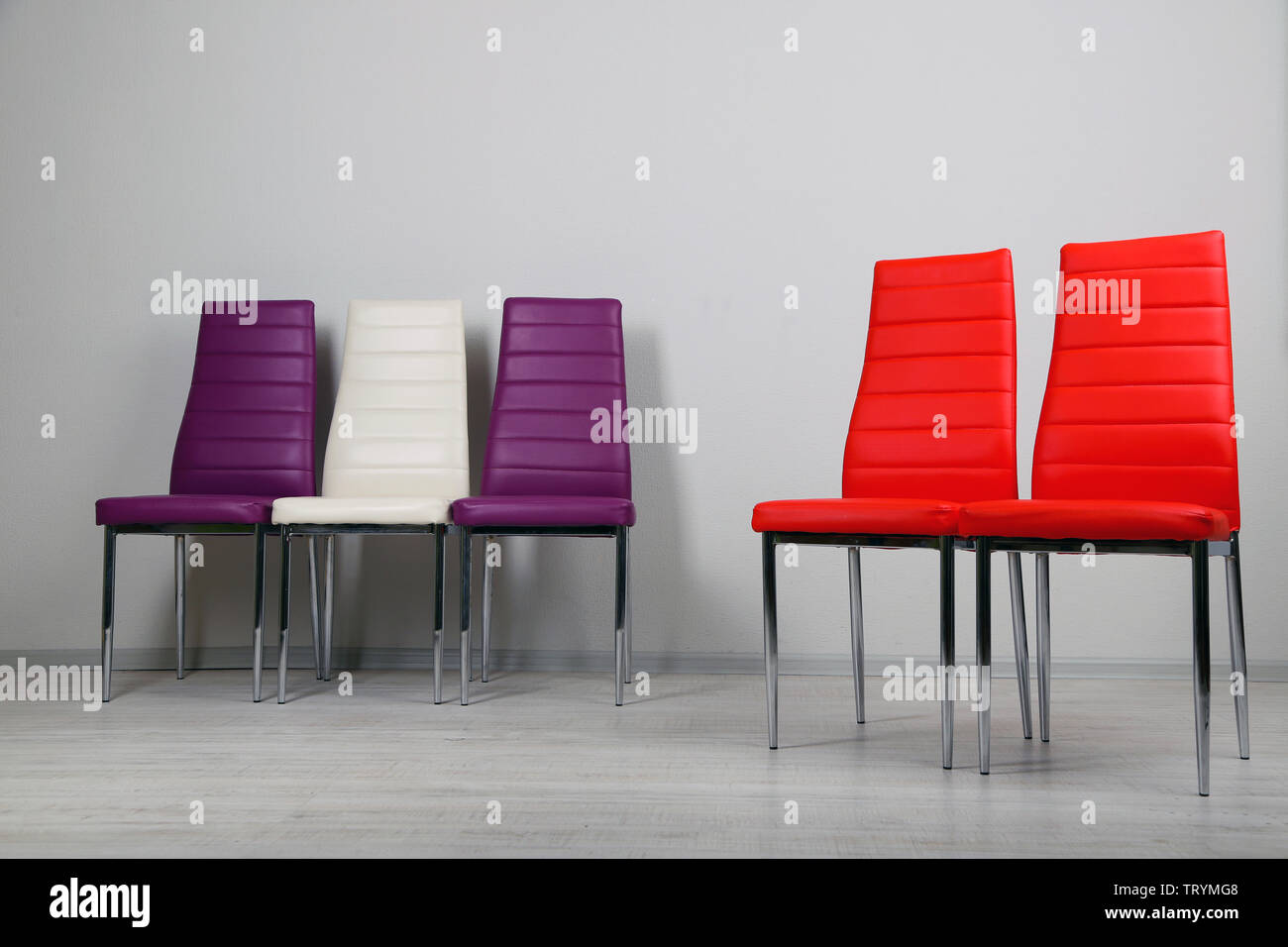 Modern color chairs on wall background Stock Photo - Alamy