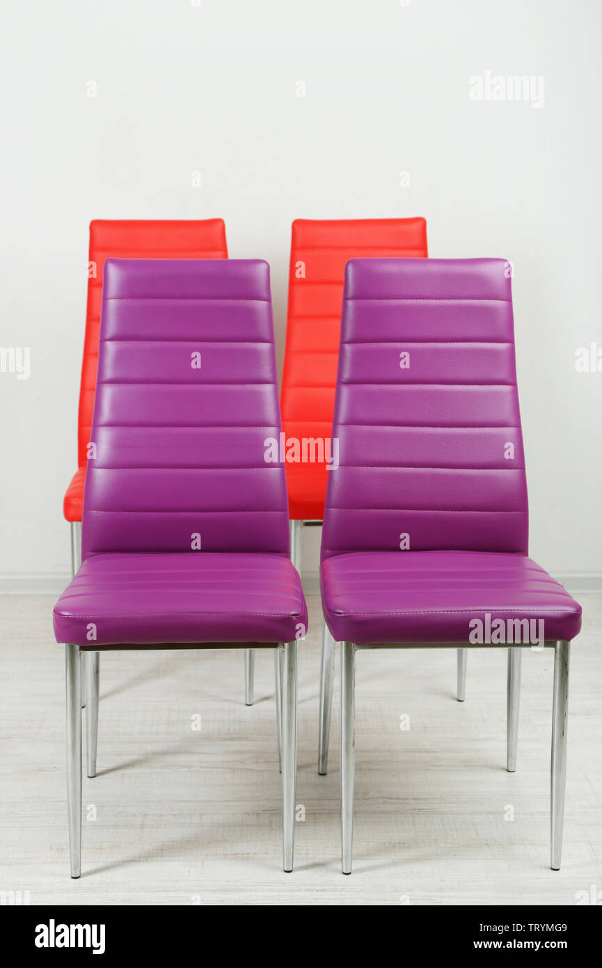 Modern color chairs on wall background Stock Photo - Alamy