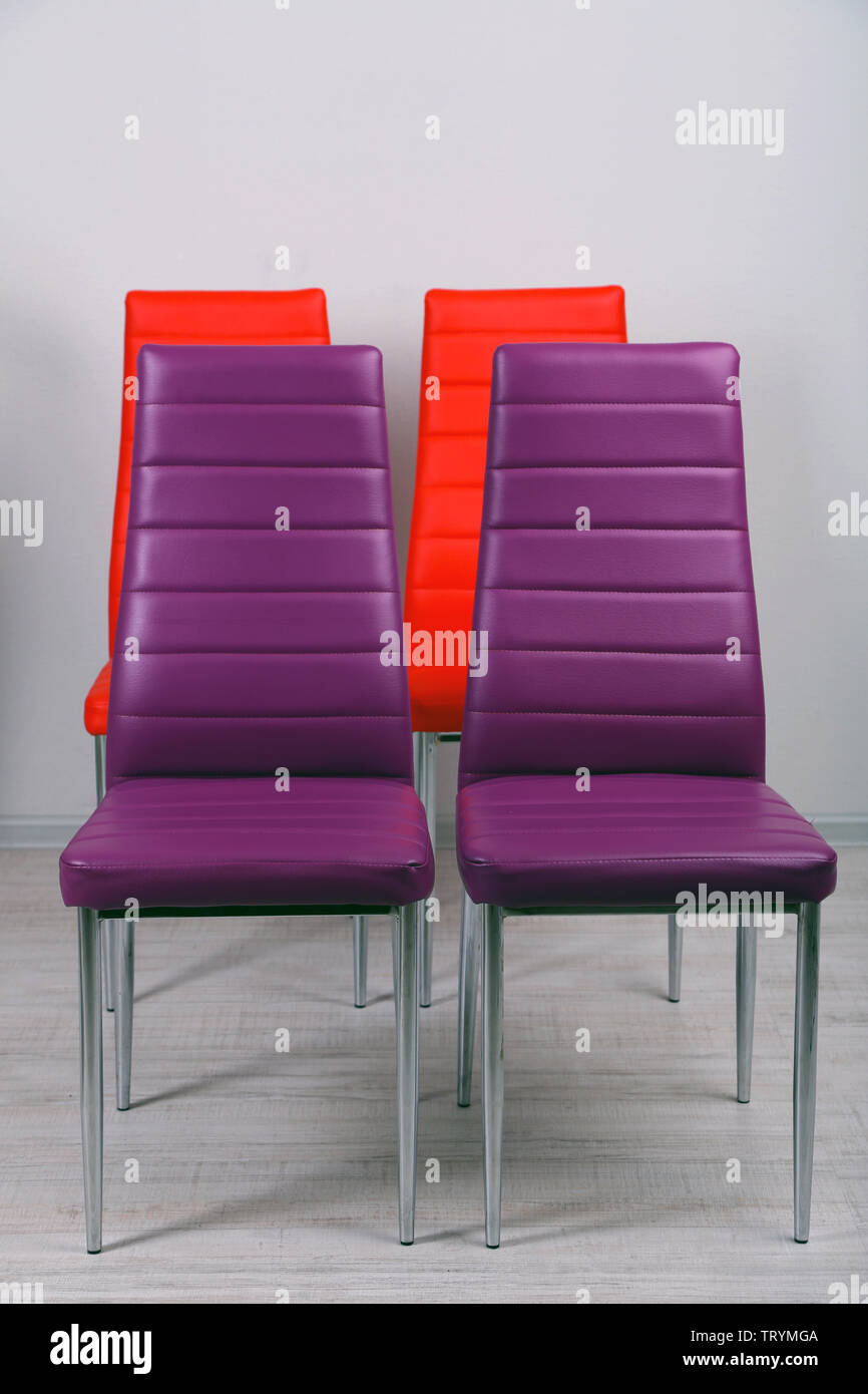 Modern color chairs on wall background Stock Photo - Alamy