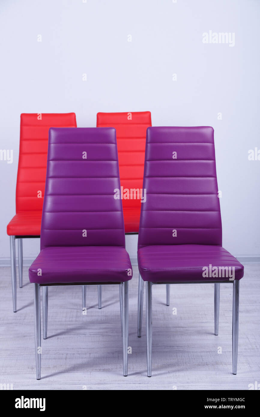 Modern color chairs on wall background Stock Photo - Alamy