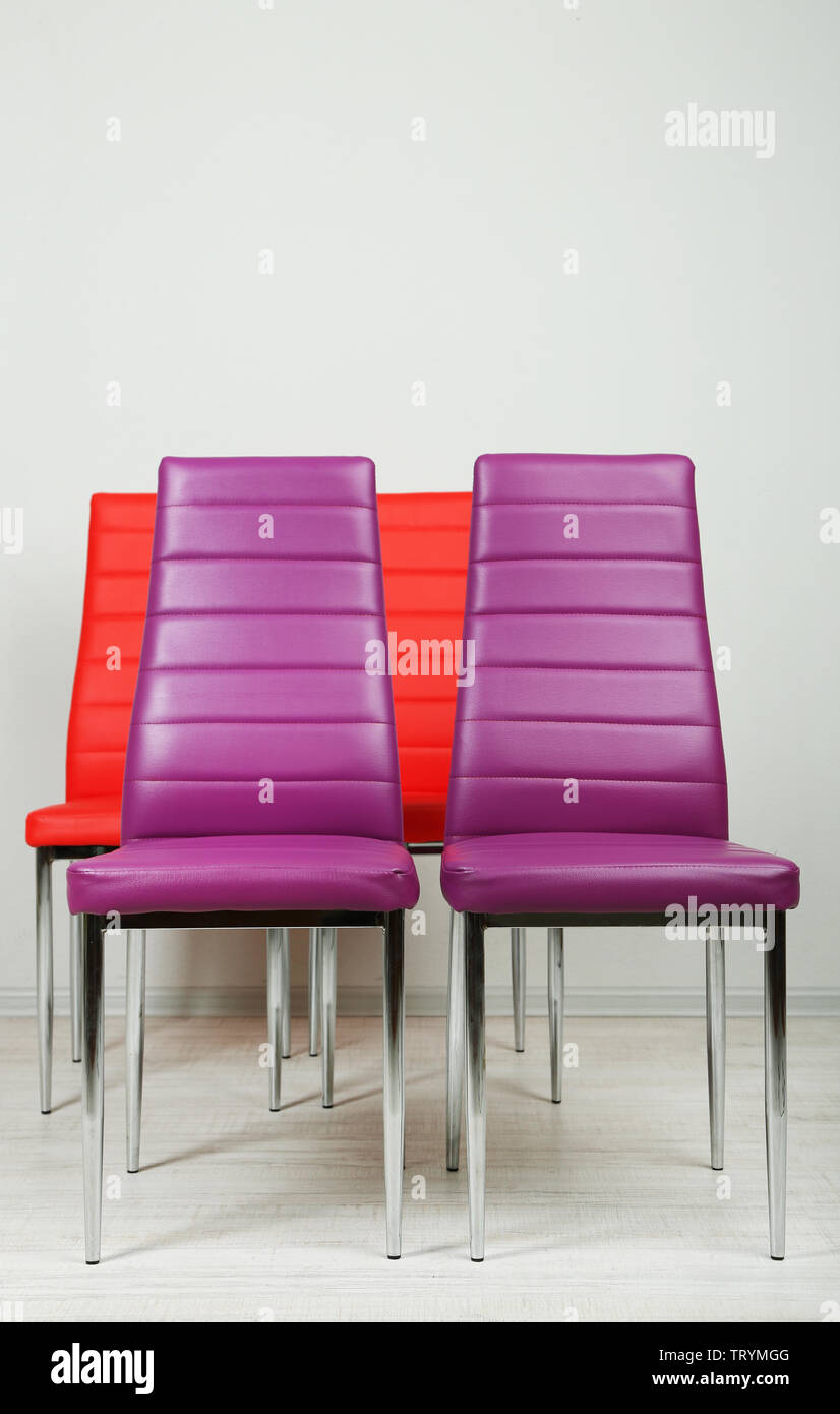 Modern color chairs on wall background Stock Photo - Alamy