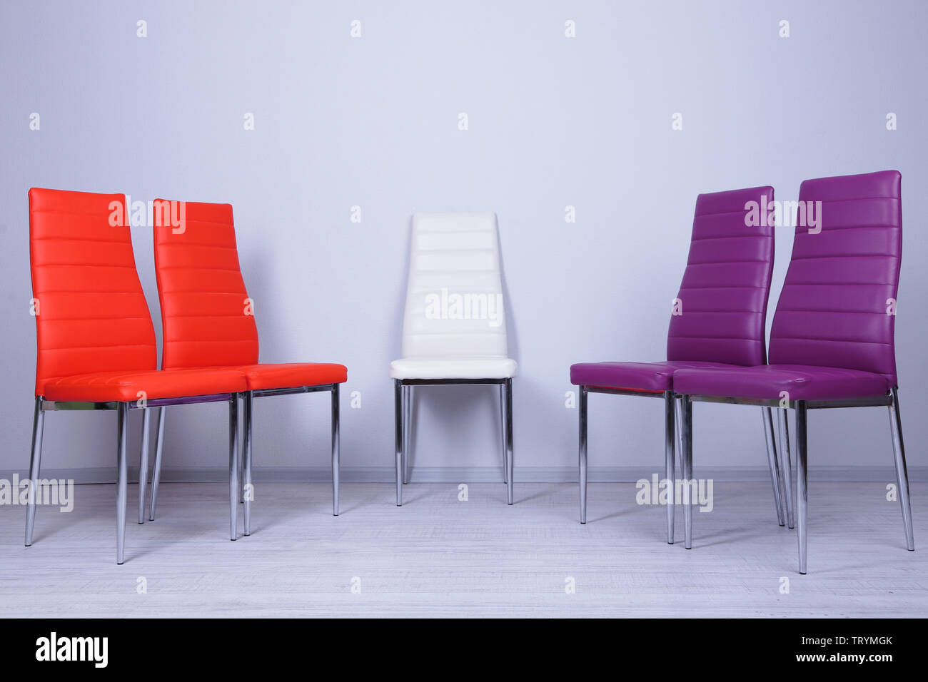 Modern color chairs on wall background Stock Photo - Alamy