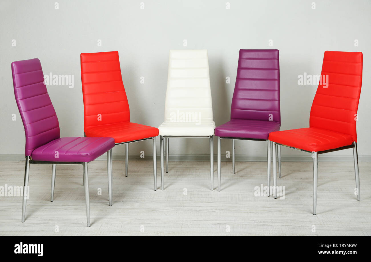 Modern color chairs on wall background Stock Photo - Alamy
