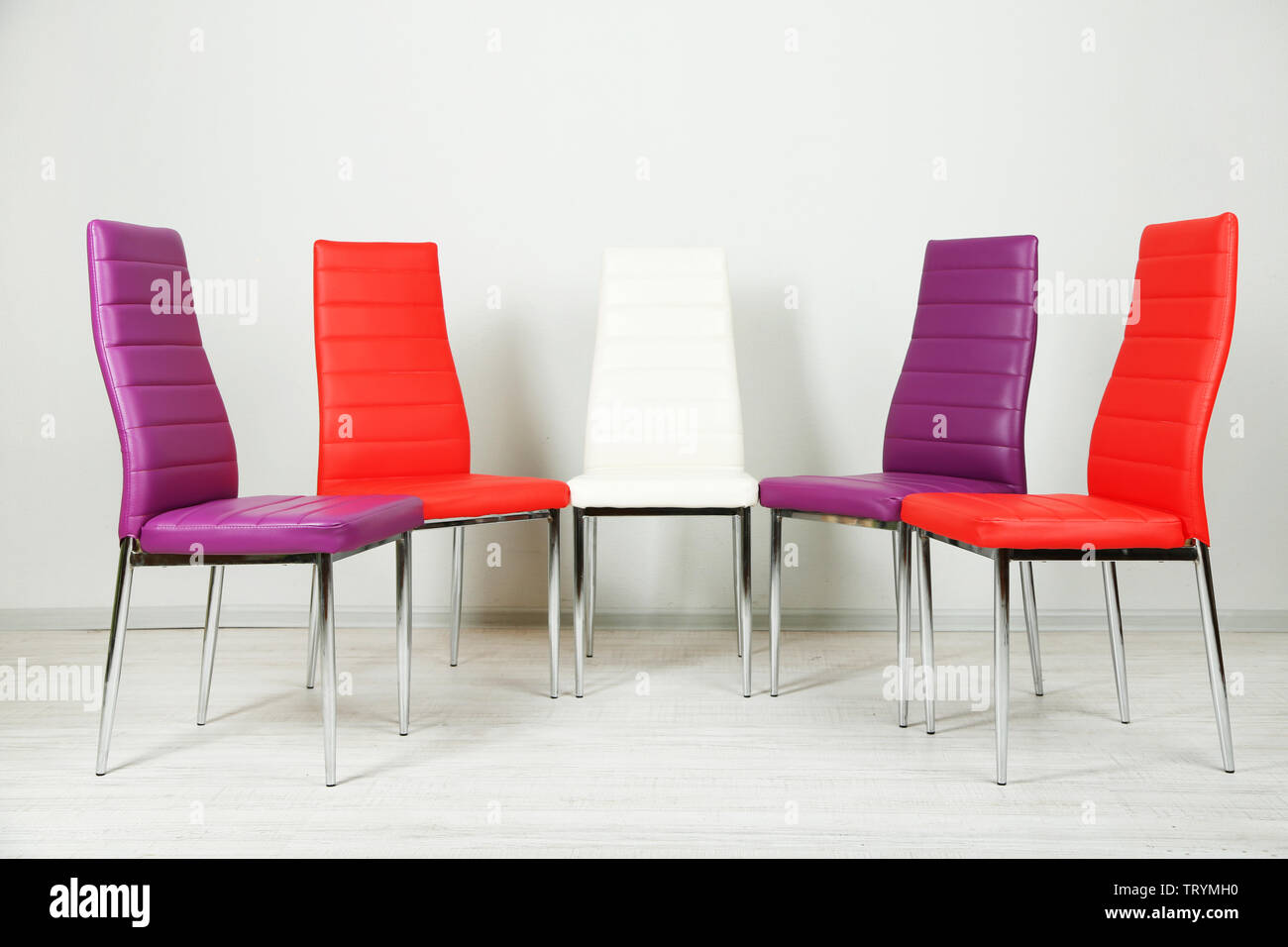 Modern color chairs on wall background Stock Photo - Alamy