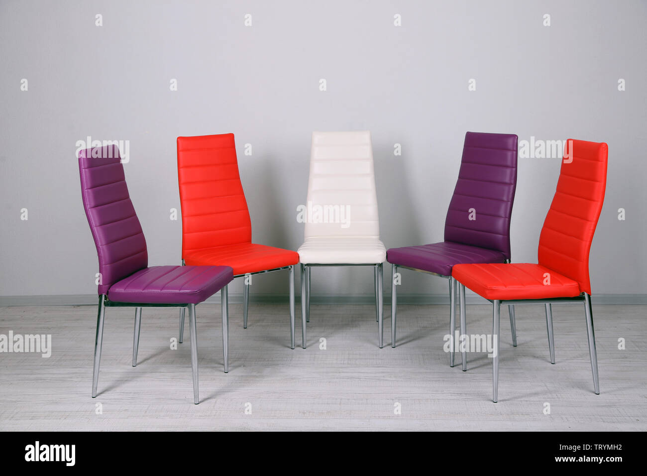 Modern color chairs on wall background Stock Photo - Alamy