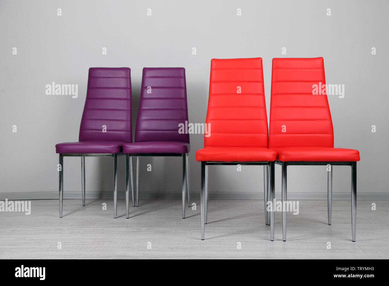 Modern color chairs on wall background Stock Photo - Alamy