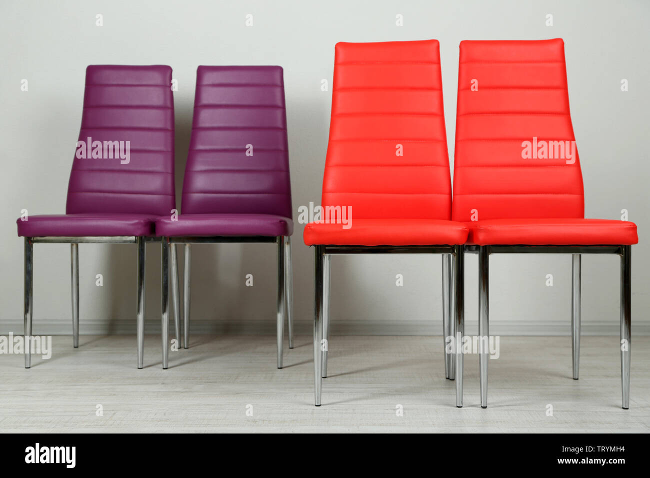 Modern color chairs on wall background Stock Photo - Alamy