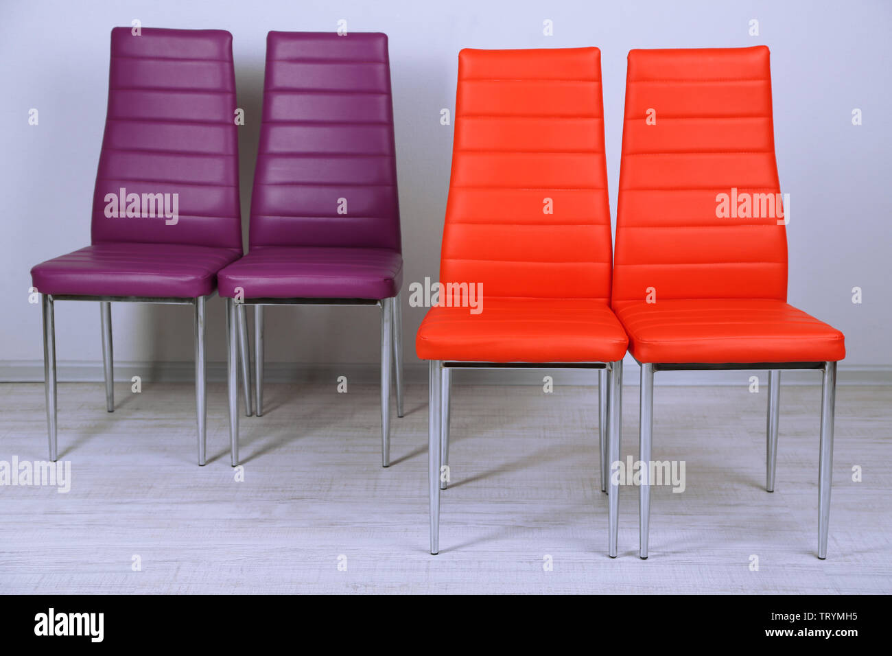 Modern color chairs on wall background Stock Photo - Alamy