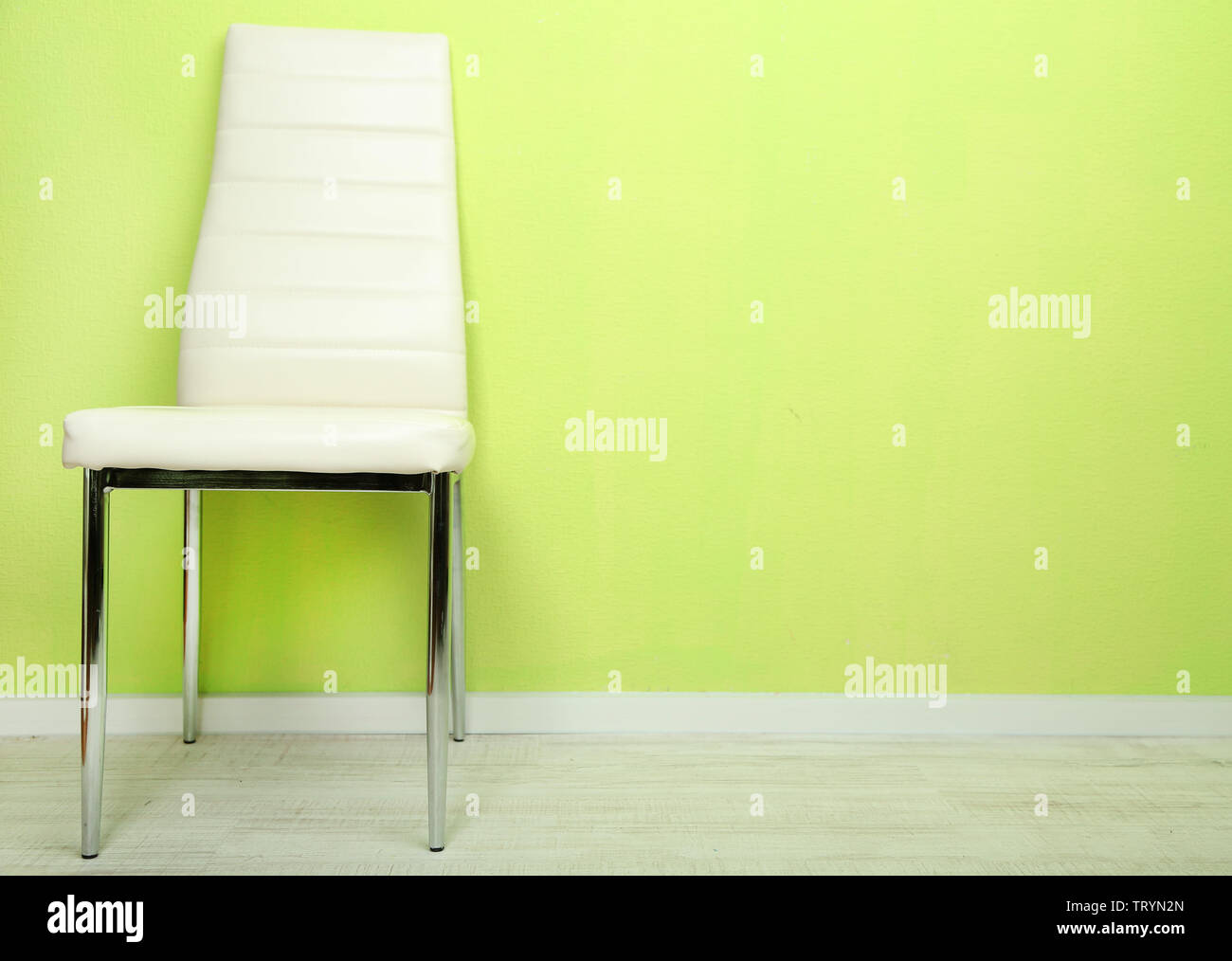 Modern color chair in empty room on wall background Stock Photo - Alamy