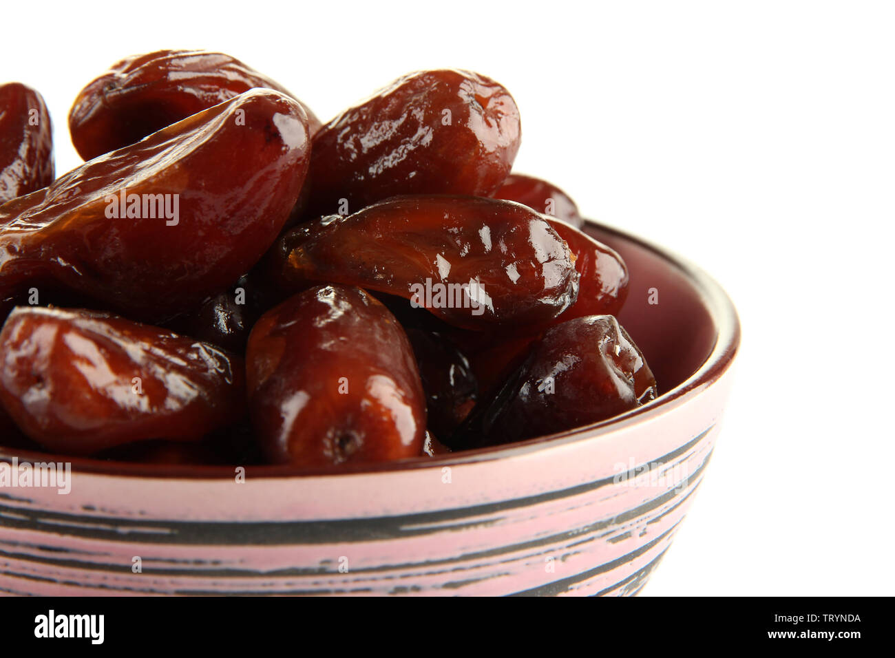 Dried dates in bowl isolated on white Stock Photo - Alamy