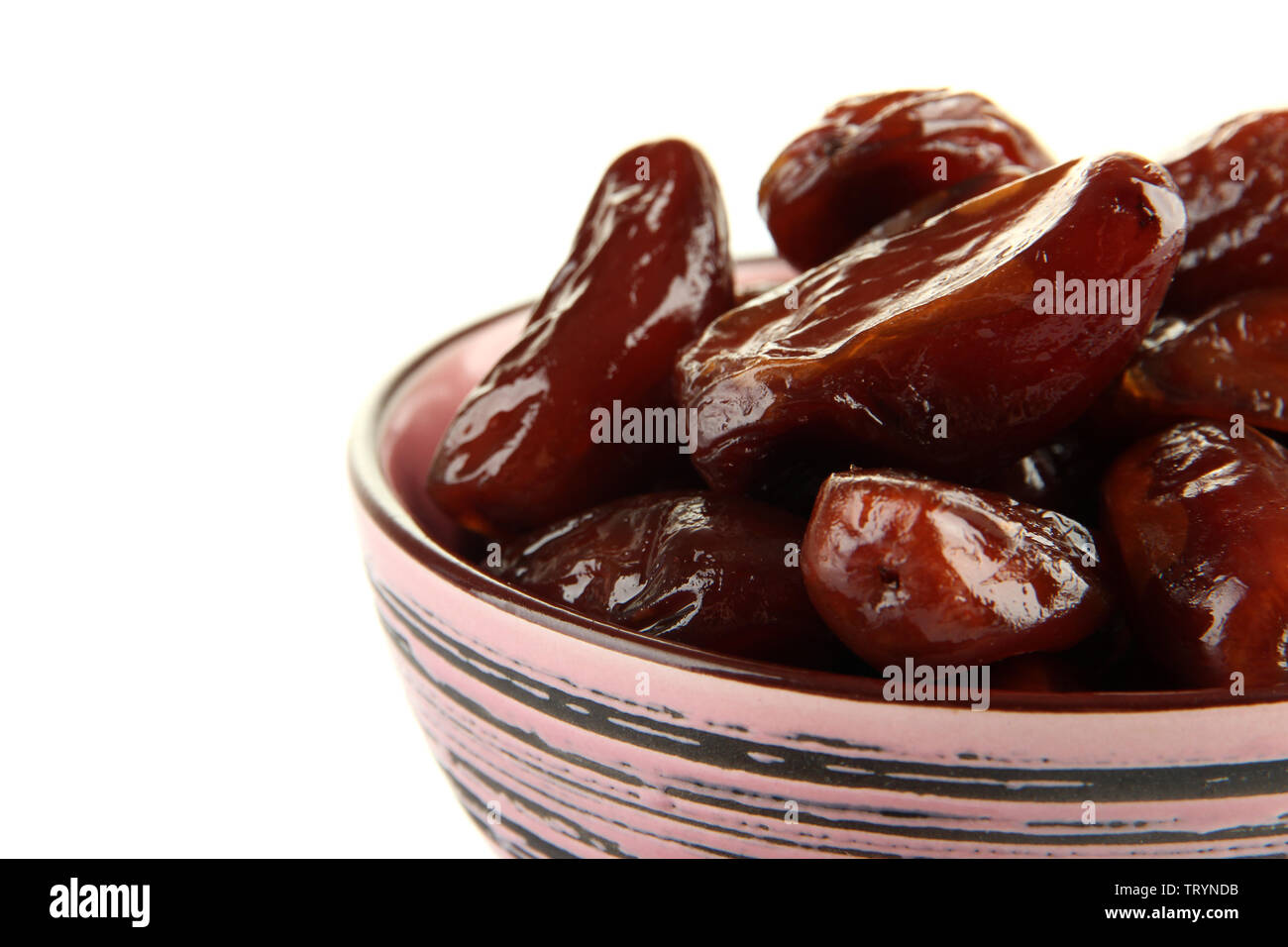 Dried dates in bowl isolated on white Stock Photo - Alamy
