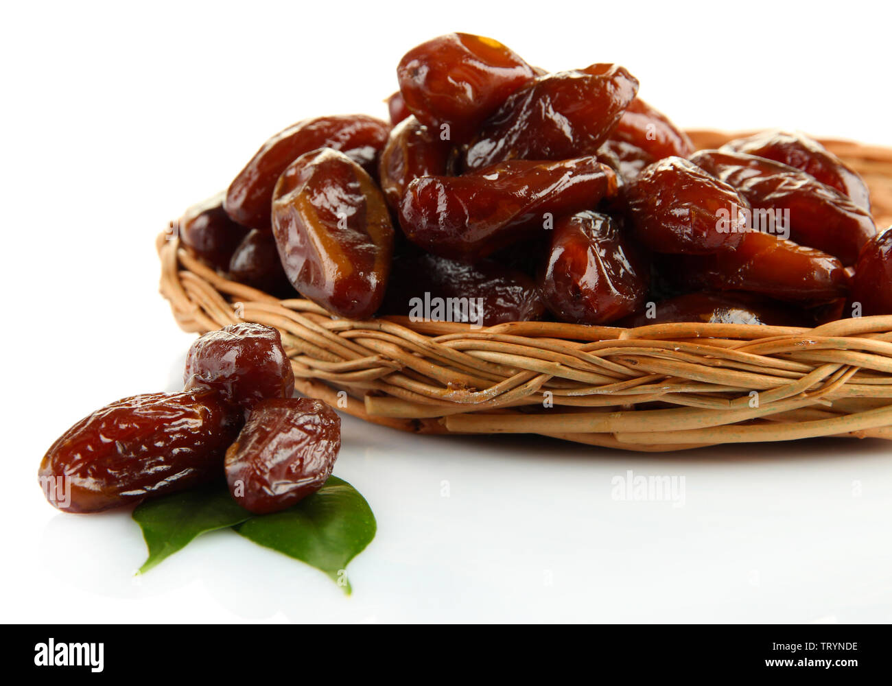 Dried dates on wicker plate isolated on white Stock Photo - Alamy