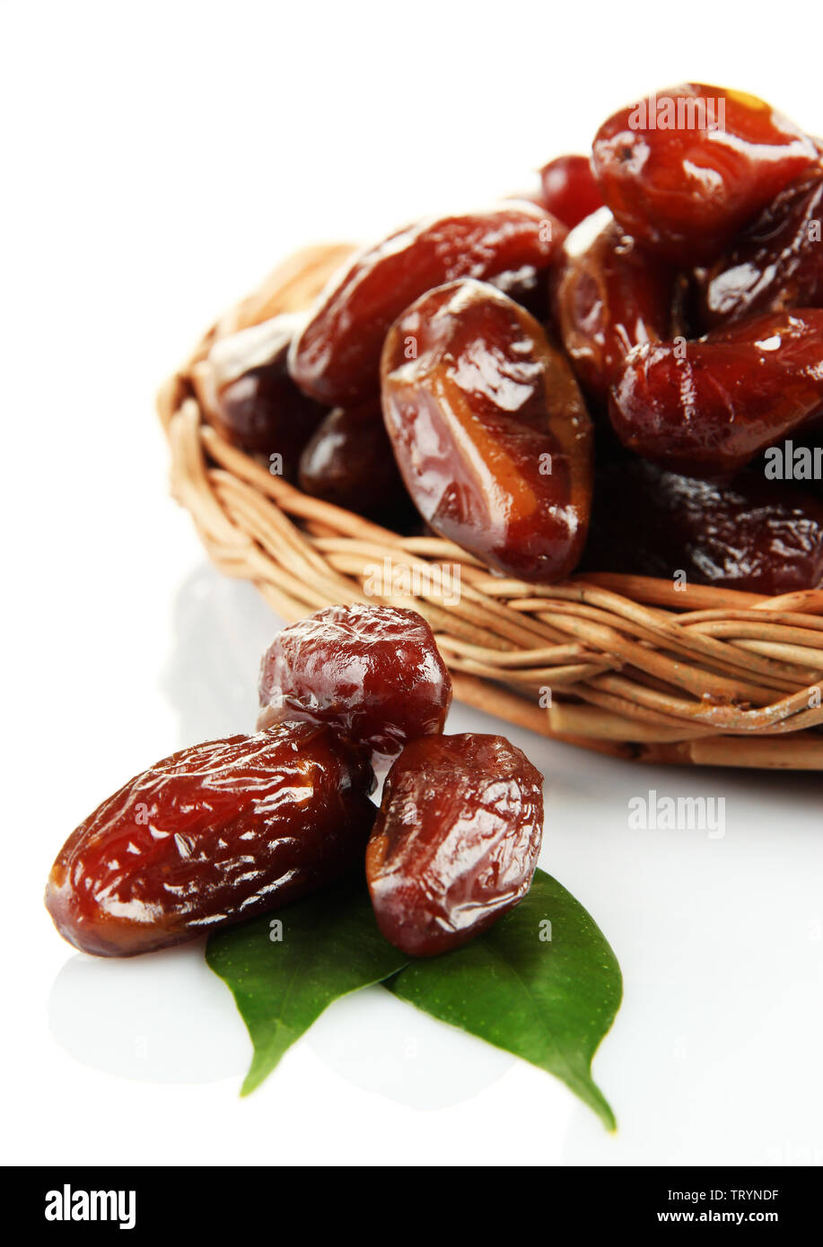 Dried dates on wicker plate isolated on white Stock Photo - Alamy