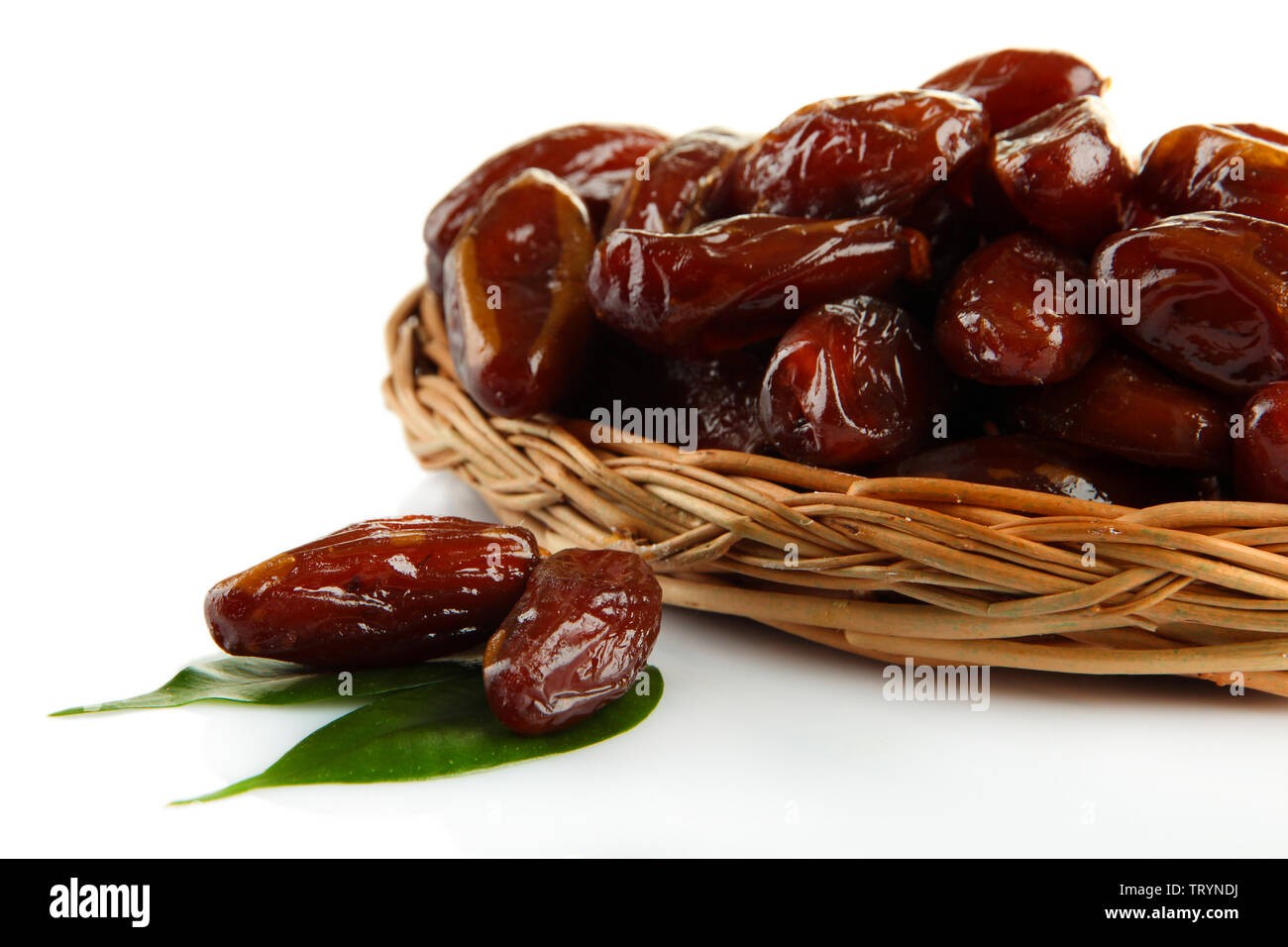 Dried dates on wicker plate isolated on white Stock Photo - Alamy